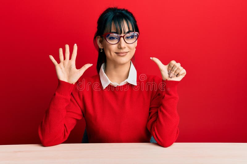 Young Brunette Woman with Bangs Wearing Glasses Sitting on the Table ... Young Brunette Woman with Bangs Wearing Glasses Sitting on the Table ...