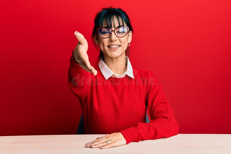 Young Brunette Woman with Bangs Wearing Glasses Sitting on the Table ... Young Brunette Woman with Bangs Wearing Glasses Sitting on the Table ...