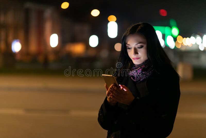 Young Brunette Woman Using Mobile Phone at Night Stock Image - Image of ...