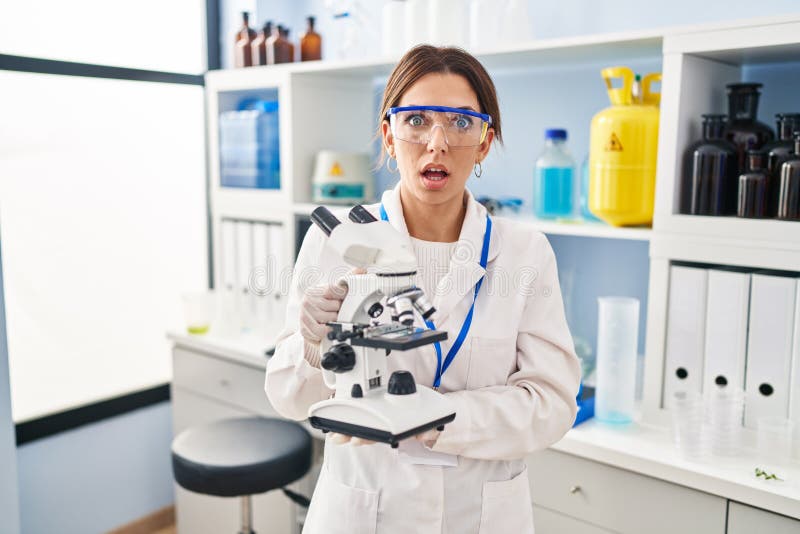 Young Brunette Woman Working at Scientist Laboratory with Microscope in ...