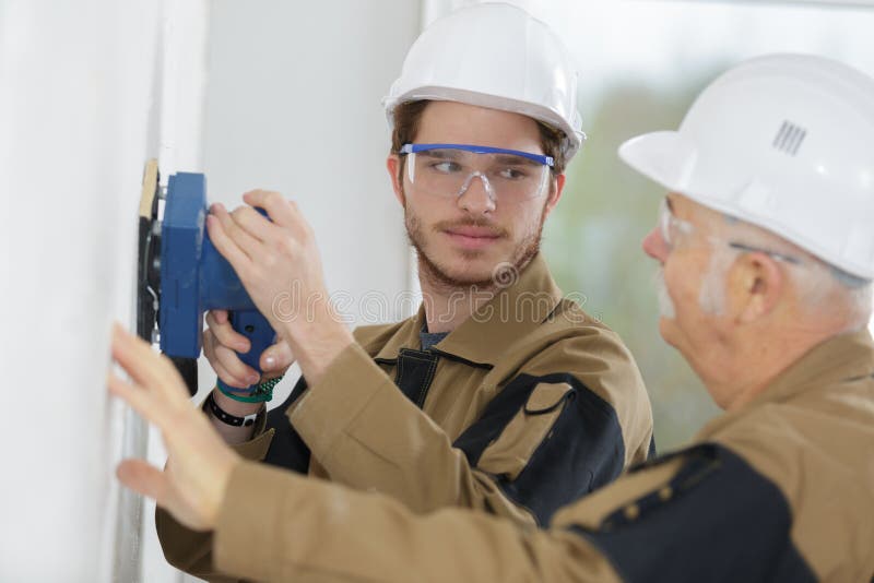 Builder and Apprentice Carrying Wood on Construction Site Stock Image ...