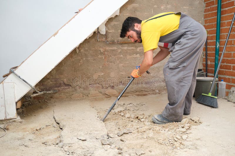 Young Builder Breaking Up a House Floor with a Crowbar. Stock Photo ...