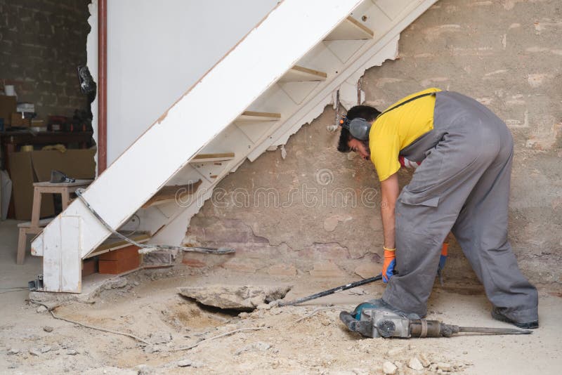 Young Builder Breaking Up a House Floor with a Crowbar. Stock Photo ...