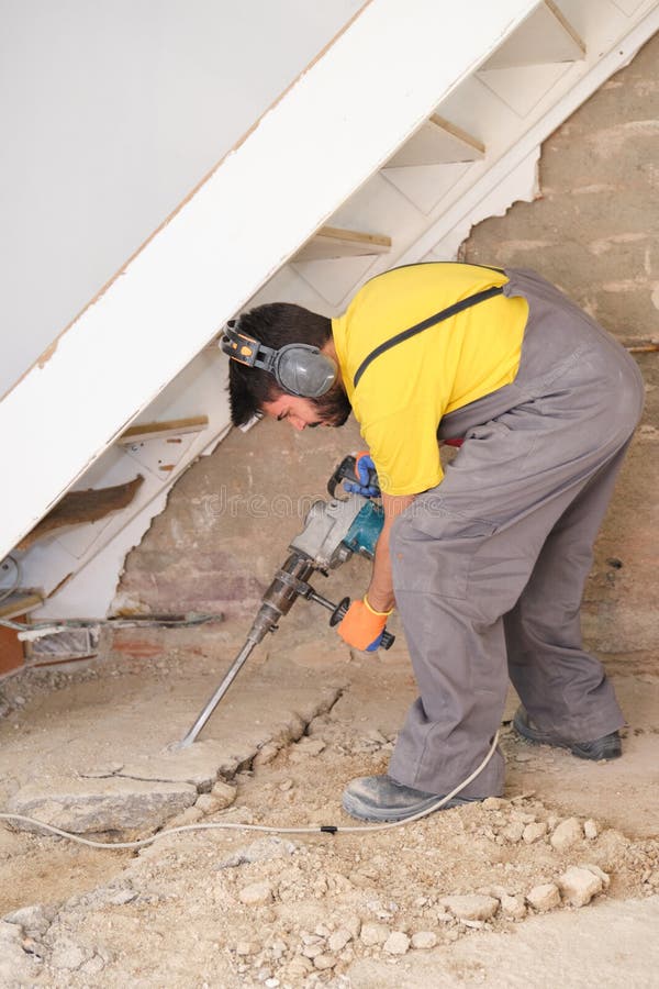 Young Builder Breaking Up a House Floor with a Jackhammer. Stock Image ...