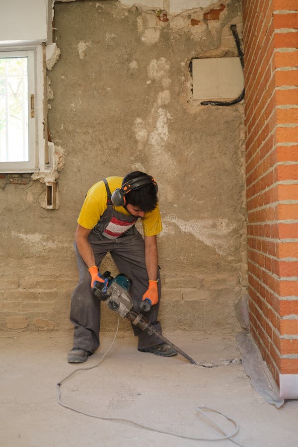 Young Builder Breaking Up a House Floor with a Jackhammer. Stock Photo ...