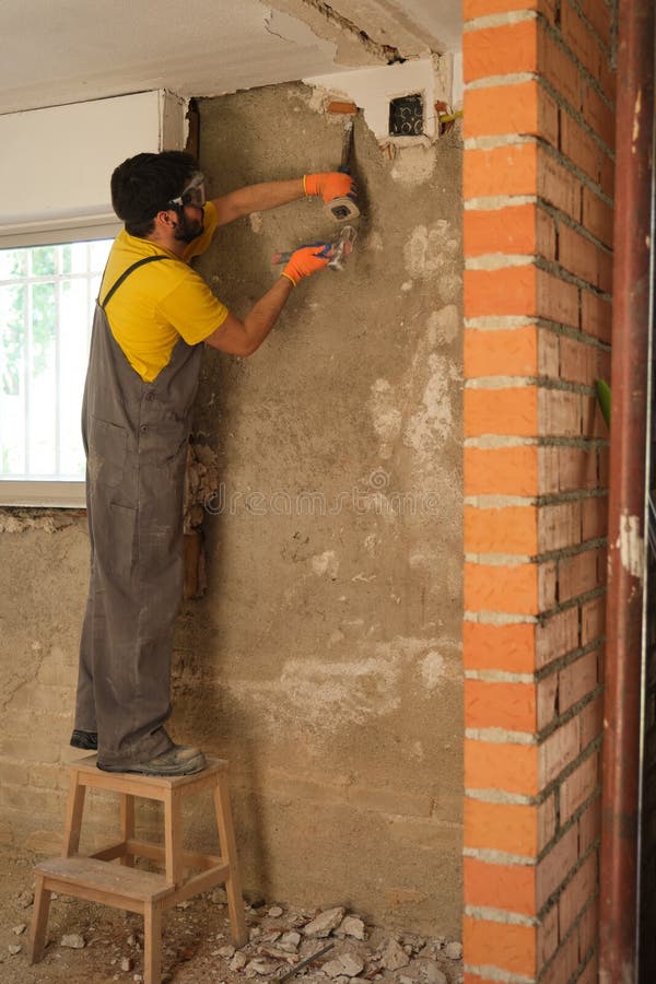 Young Builder Breaking Up a House Wall with a Hammer and a Chisel ...