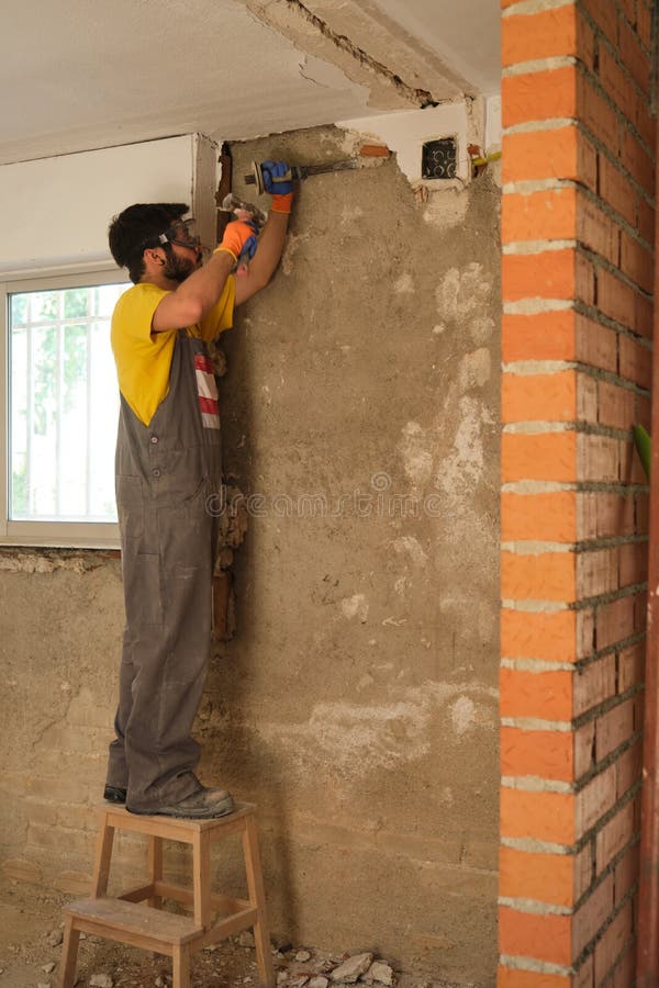 Young Builder Breaking Up a House Wall with a Hammer and a Chisel ...