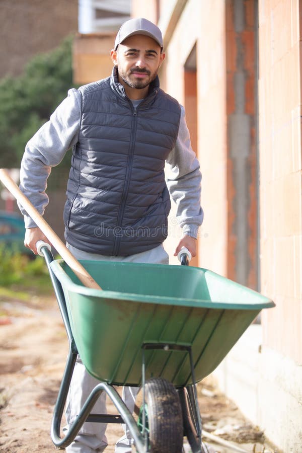 Young Builder Pushing Wheelbarrow Stock Photo - Image of skill, manual ...