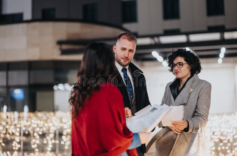 Young Business Colleagues Engage in a Conversation about Work Documents ...