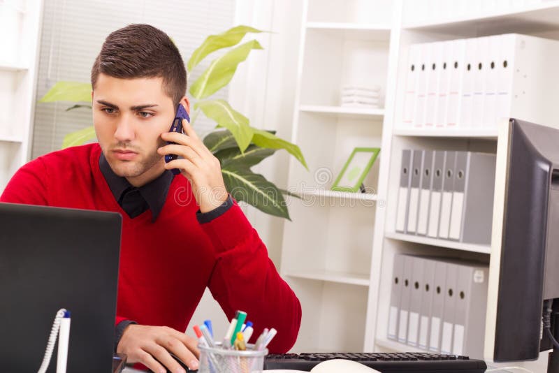 Young Business Man on Phone while Using Computer Stock Photo - Image of ...