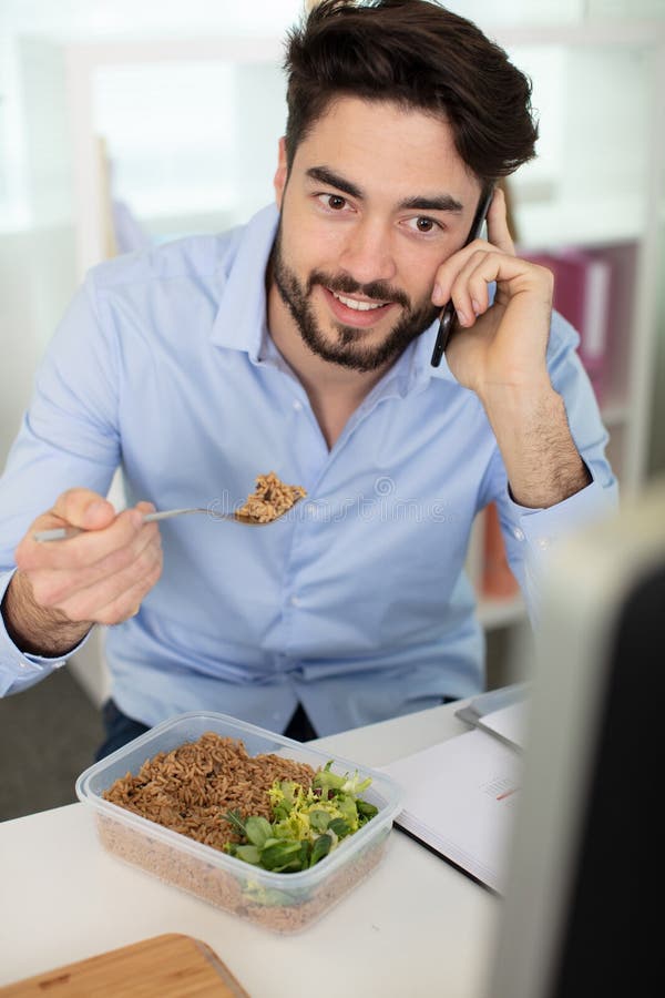 Young Business Man Talking on Phone while Eating Stock Photo - Image of ...