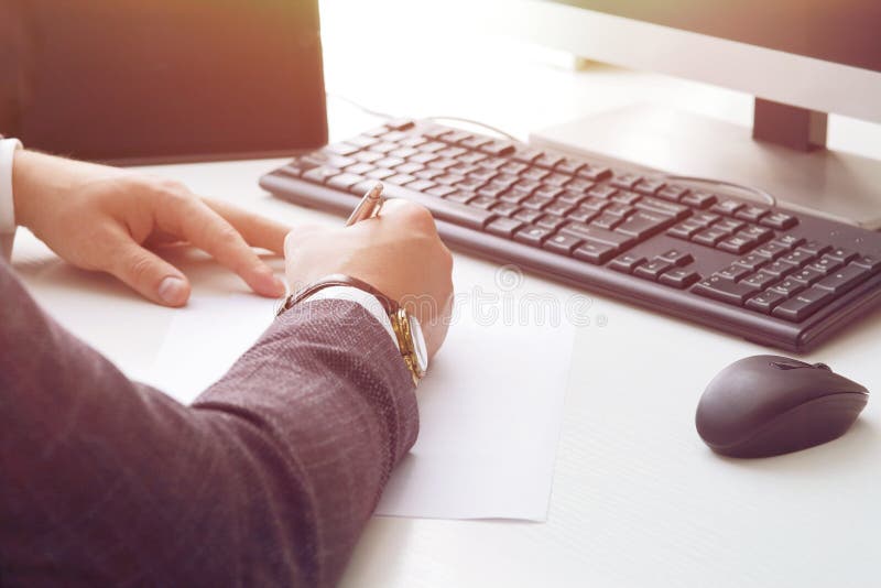Young Business Man Working at the Computer and Papers on the Table ...