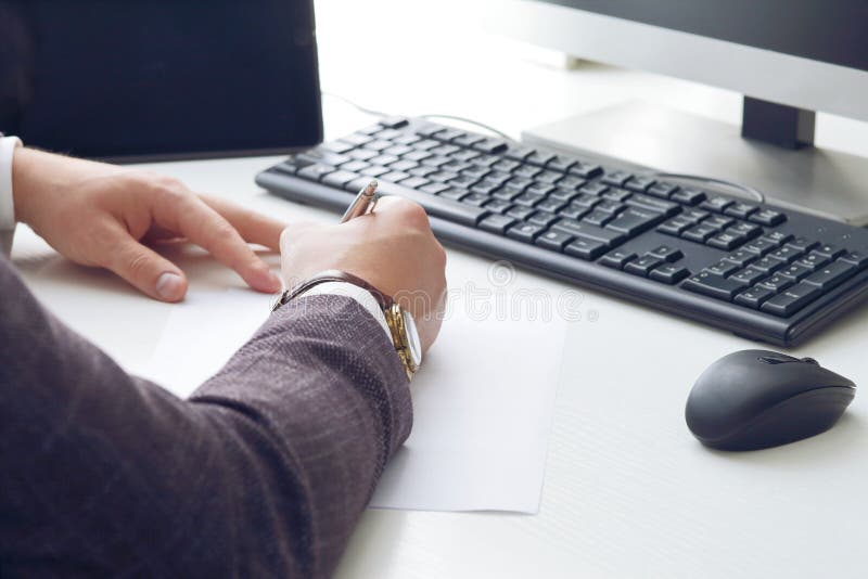 Young Business Man Working at the Computer and Papers on the Table ...