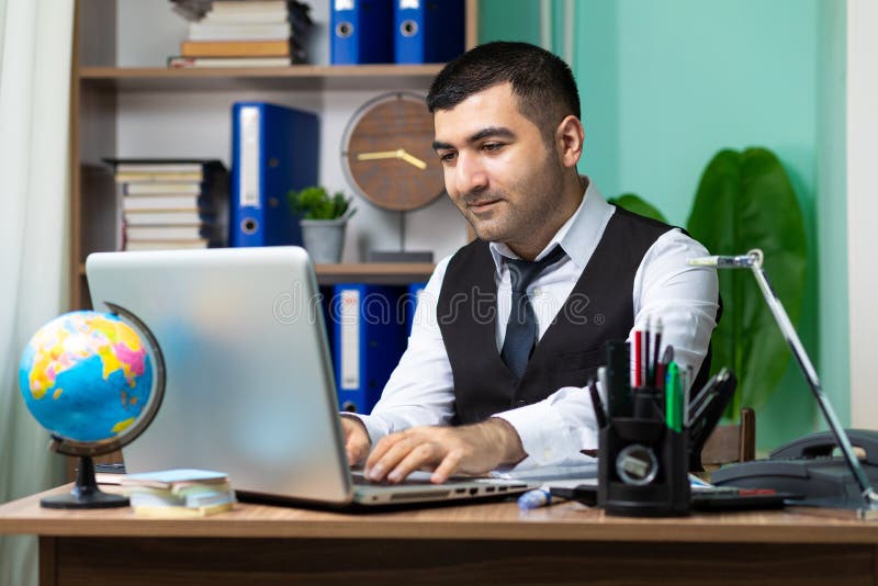 Young Business Man Working on Laptop at Table in Office Stock Image ...