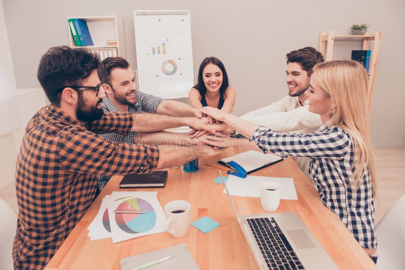 Young Business Team Putting Their Hands on Top of Each Other at ... Young Business Team Putting Their Hands on Top of Each Other at ...