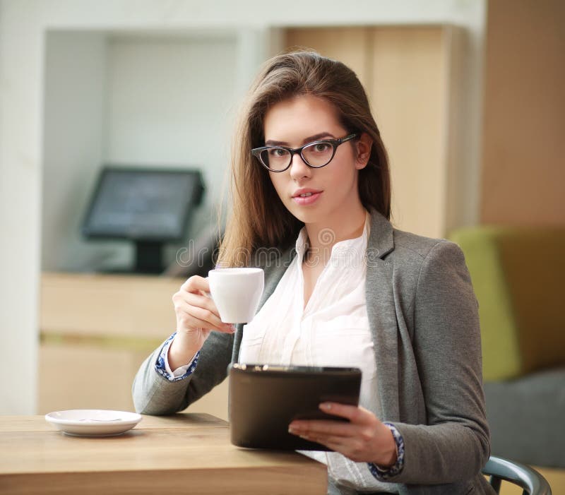 Young Business Woman with a Cup of Coffee Working in Office Stock Photo ...