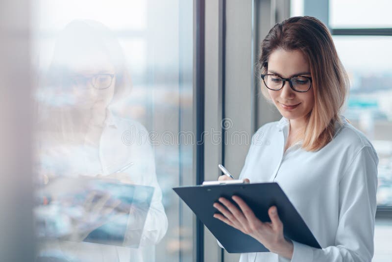 Young Business Woman Signing Documents in a Modern Office Stock Photo ...