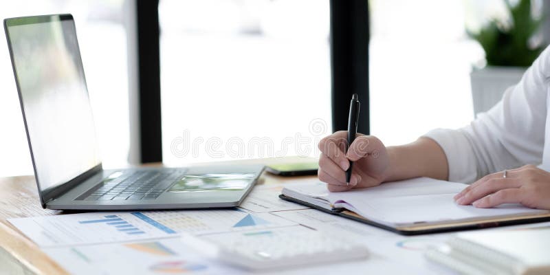 Young Business Woman Sitting at Table and Taking Notes in Notebook.on ...