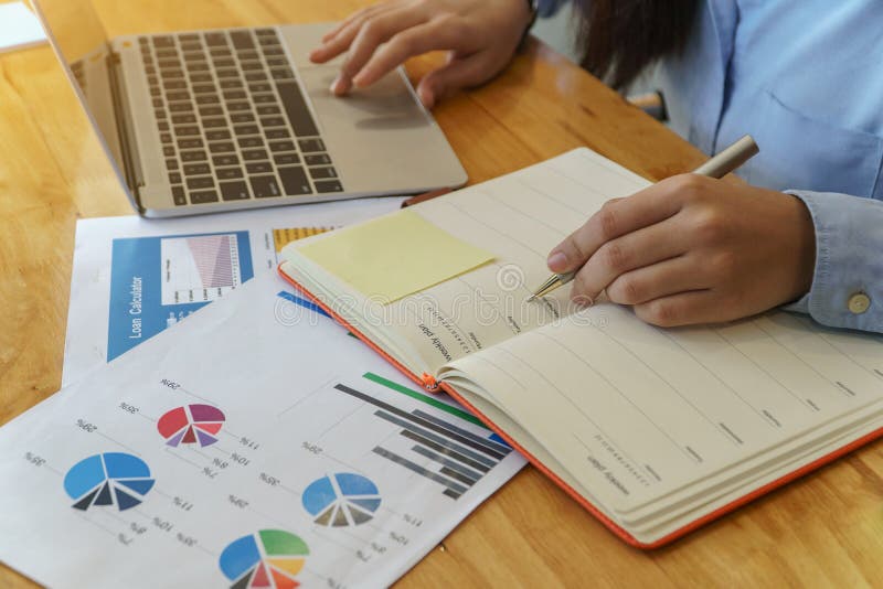 Young Business Woman Sitting at Table and Taking Notes in Notebook.Loan ...