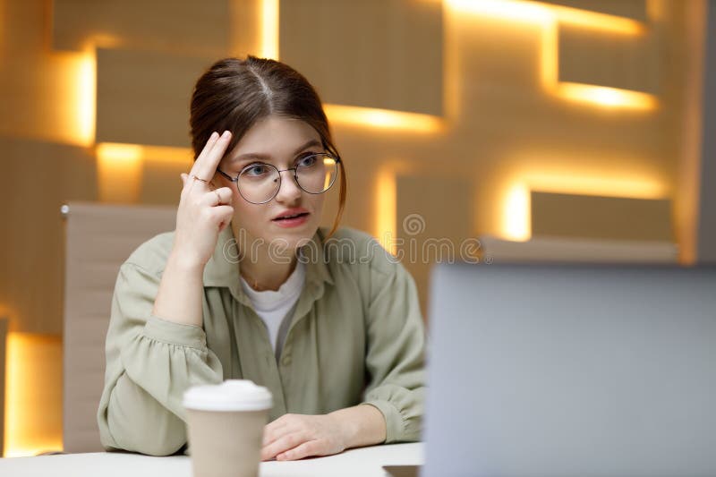 Young Business Woman Thinks with Her Head at the Workplace in the ...