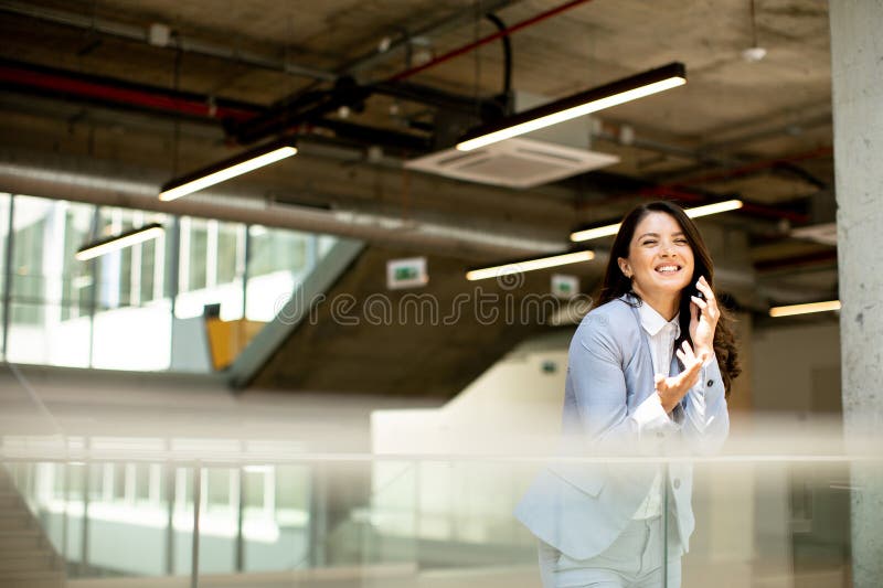 Young Business Woman Using Mobile Phone in the Office Hallway Stock ...