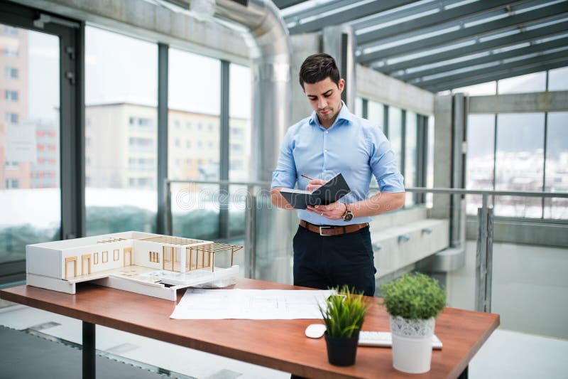 Young Businessman or Architect with Model of a House Standing in Office ...