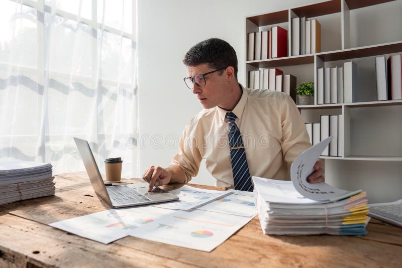 Young Businessman Working Diligently in a Modern Office Setting with ...