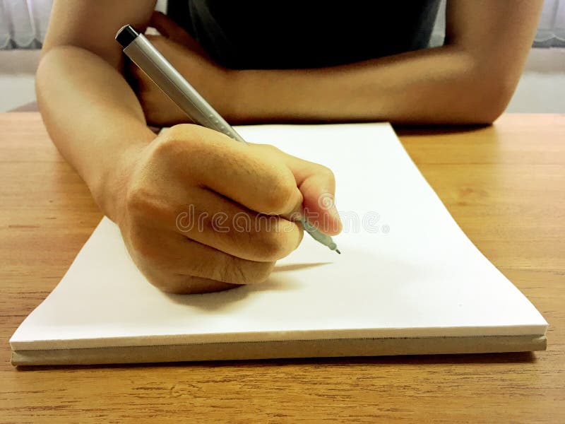 Young Businessman Holding Pen and Hand Writing on Notebook in Office ...