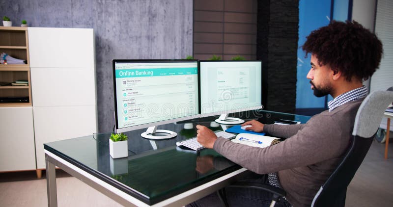 Young Businessman Looking at Invoice while Doing Online Banking Stock ...