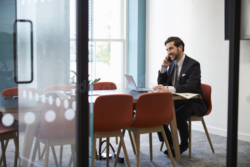 Young Businessman Making a Phone Call in a Boardroom Stock Photo ...