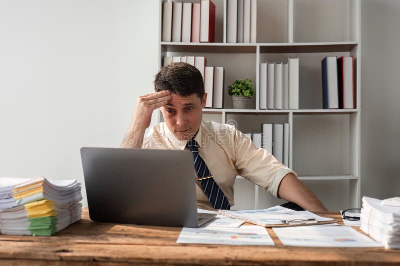 Young Businessman Focused on Work at Desk with Laptop and Documents in ...
