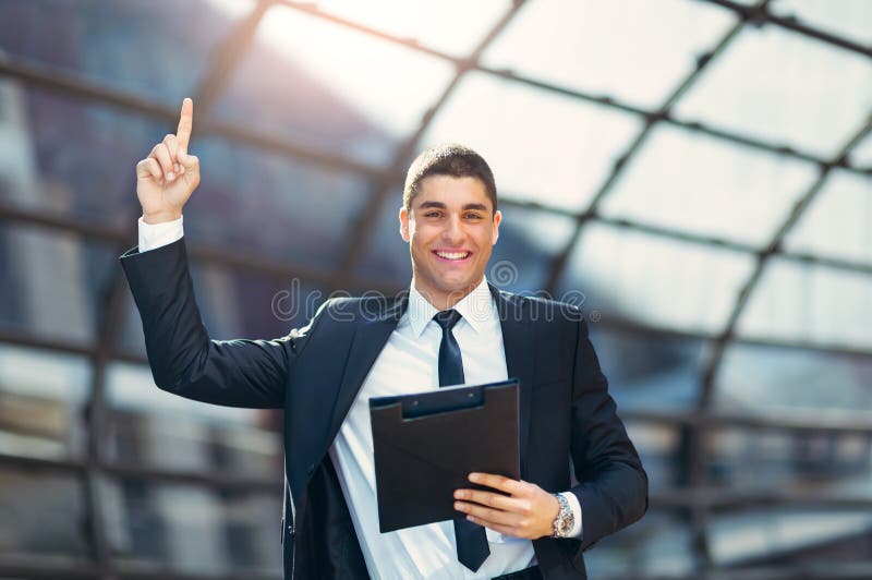 Young Businessman Pointing Up Outside of an Office Building Stock Photo ...