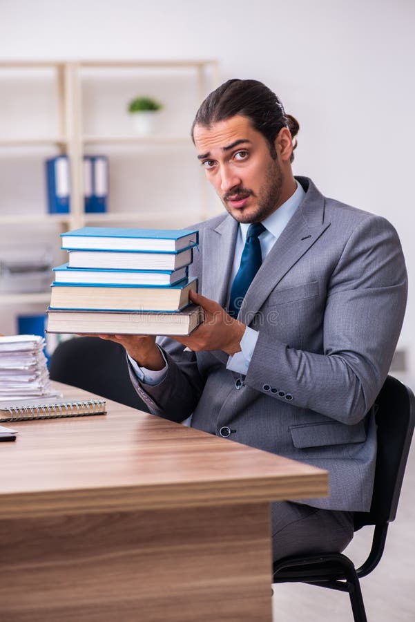 Young Male Businessman Reading Books at Workplace Stock Photo - Image ...