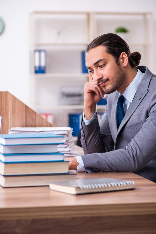 Young Male Businessman Reading Books at Workplace Stock Image - Image ...