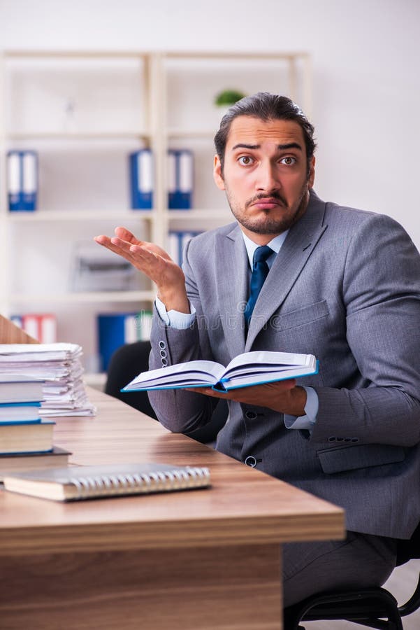 Young Male Businessman Reading Books at Workplace Stock Image - Image ...