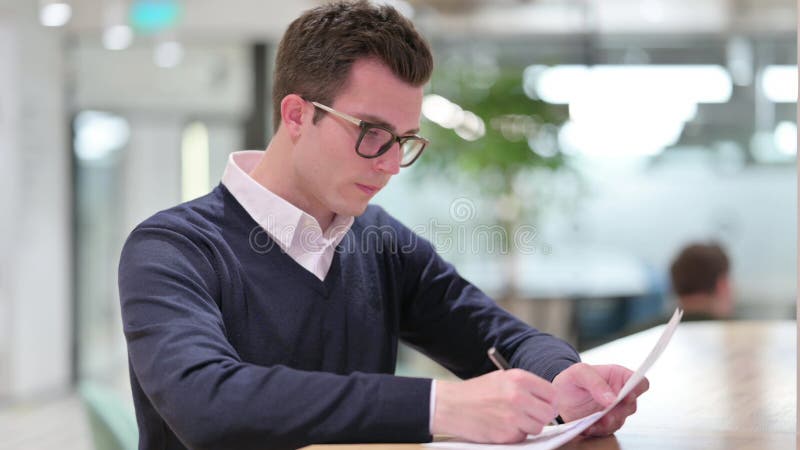 Young Businessman Reading Documents at Work Stock Image - Image of busy ...