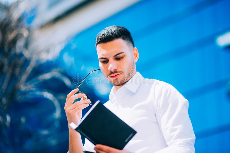 Young Businessman is Reading His Notebook Stock Photo - Image of ...