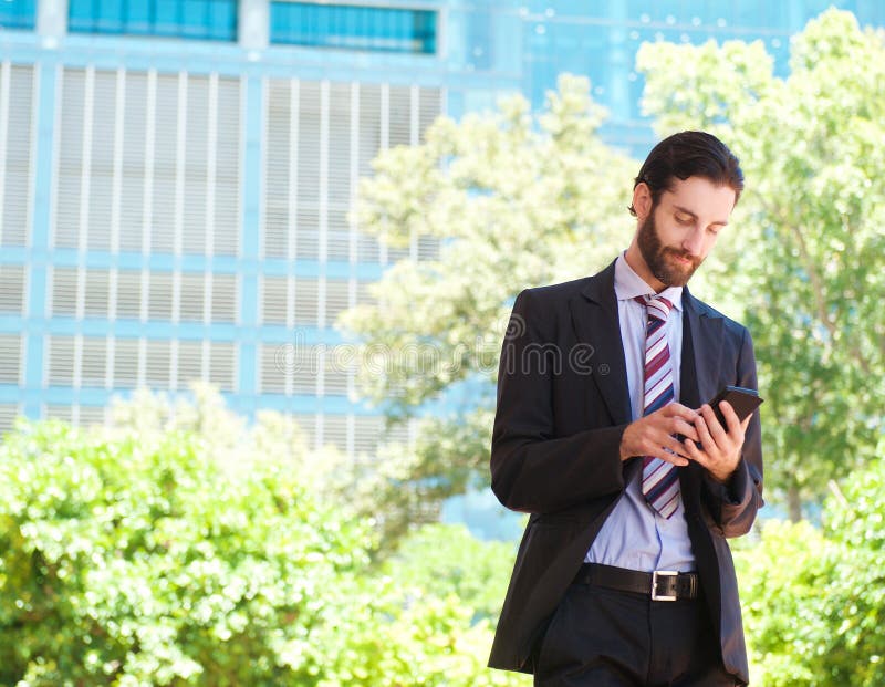 Young Businessman Reading Text Message on Mobile Phone Stock Photo ...