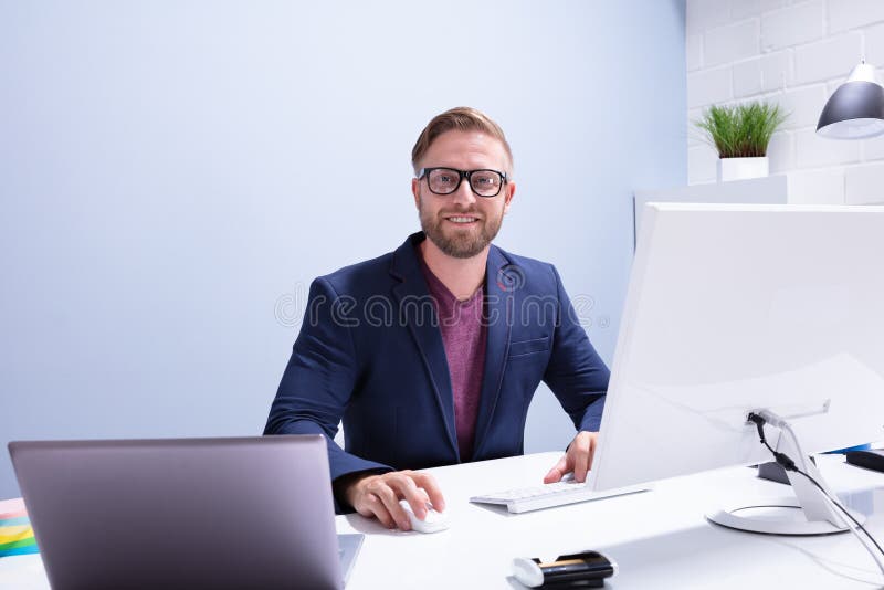 Young Businessman Sitting in Front of Computer Stock Image - Image of ...