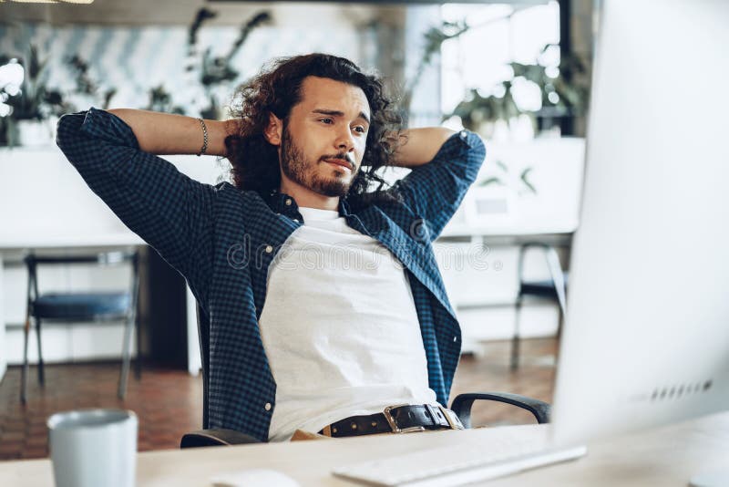 Young Businessman Sitting in Office with Hands Behind His Head ...
