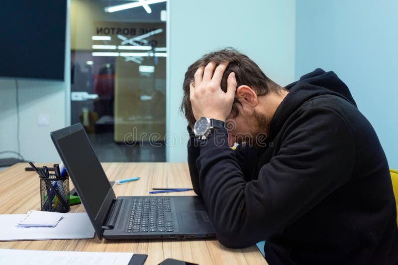 Young Businessman Sitting at the Office Table at Work in Depression ...