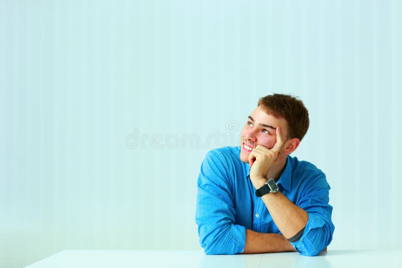 Young Businessman Sitting at the Table and Looking Up Stock Photo ...