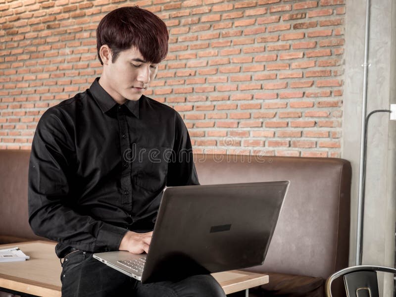 Young Businessman Standing at Desk, Working with Laptop Computer on the ...