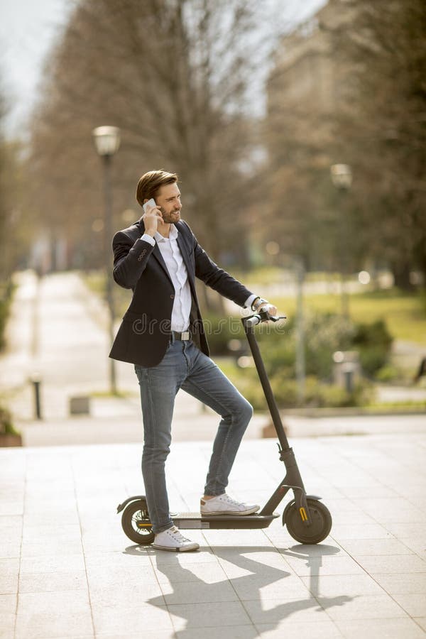 Young Businessman Using Mobile Phone on Electric Scooter Stock Photo ...