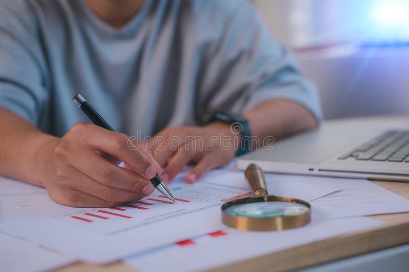 Young Businessman Using Pen Working on Desk with Computer and Paperwork ...