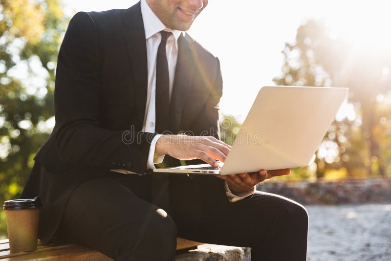 Young Businessman Walking Outdoors Using Laptop Computer Stock Photo ...