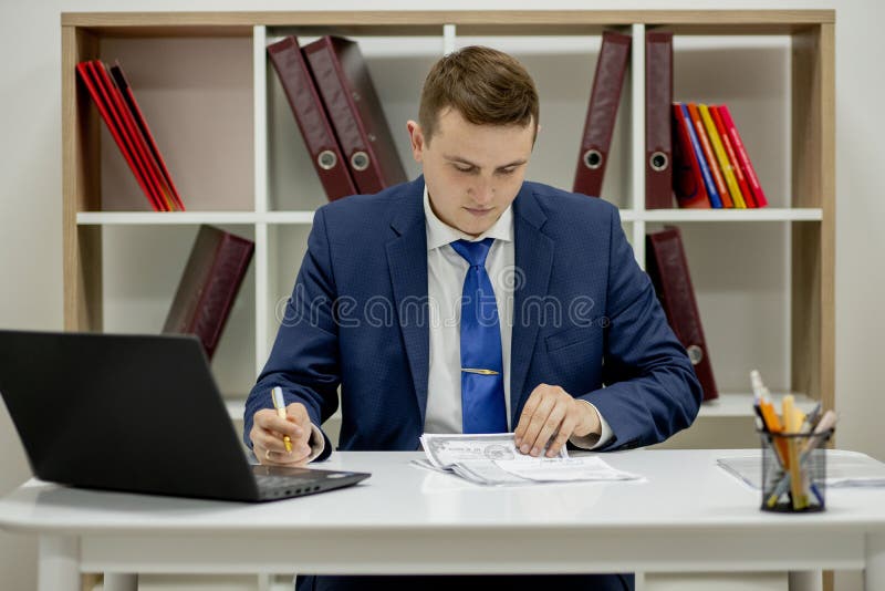 Young Businessman Working with Documents Looking through Papers in ...