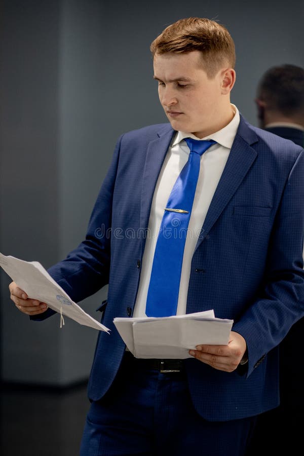 Young Businessman Working with Documents Looking through Papers in ...
