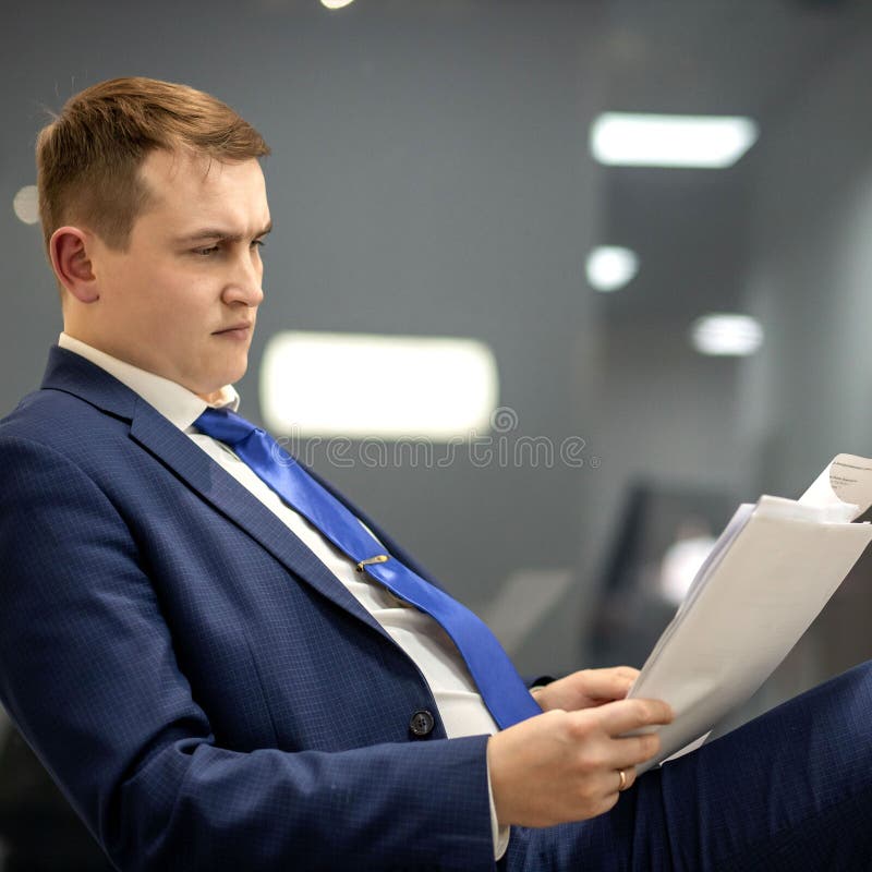Young Businessman Working with Documents Looking through Papers in ...