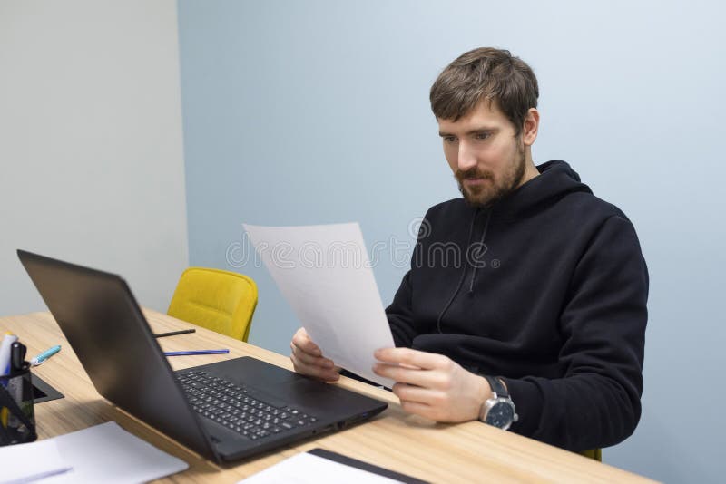 Young Businessman Working with Documents in the Office. Person Reading ...
